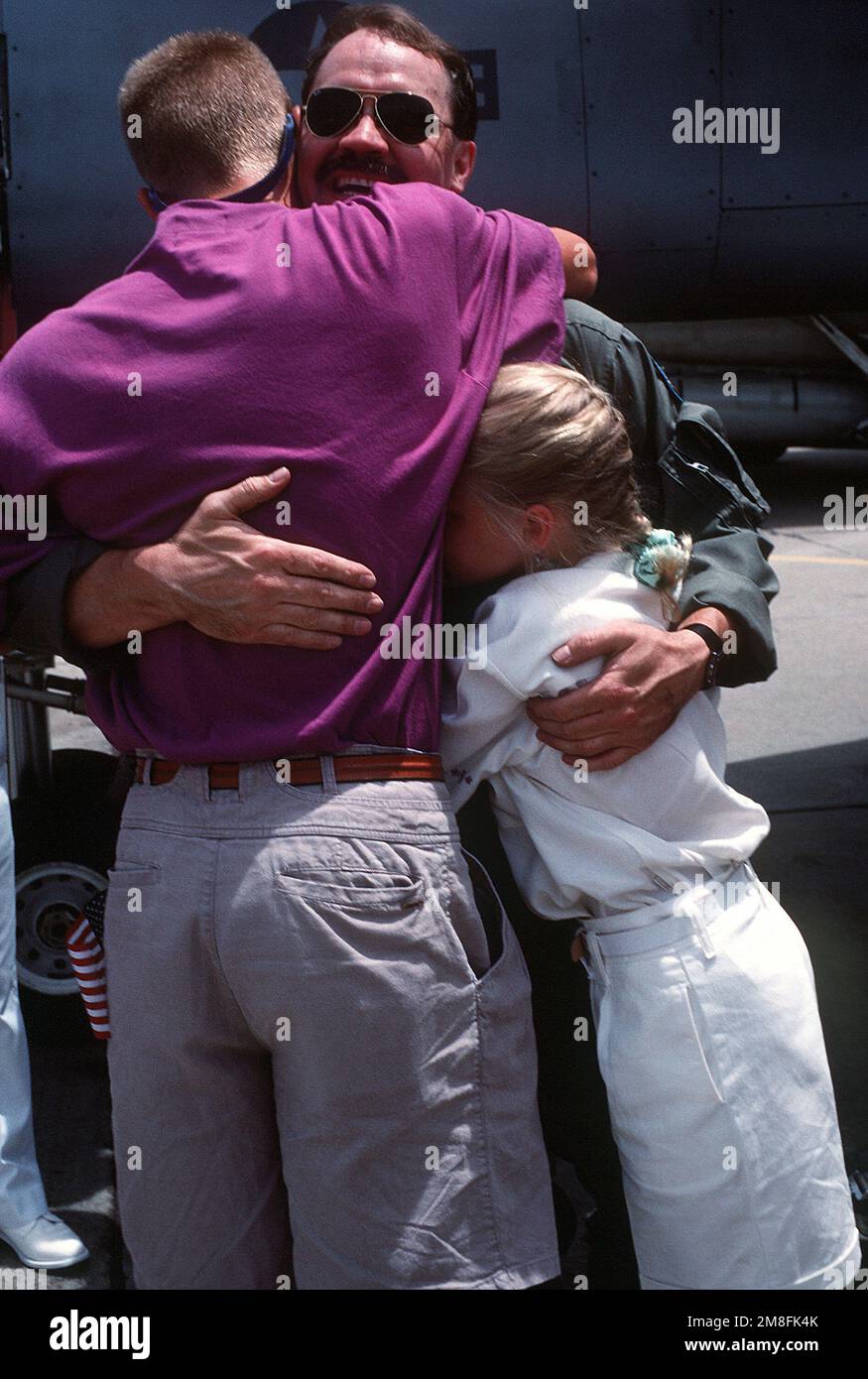 A radar intercept officer from Fighter Squadron 41 (VF-41) embraces his son and daughter as they ...