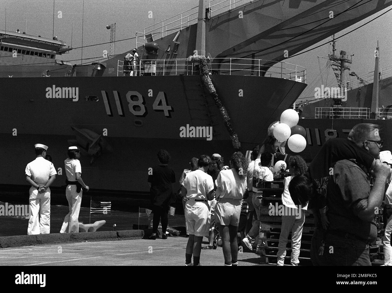Family members and friends wait on the pier beside the tank landing ...