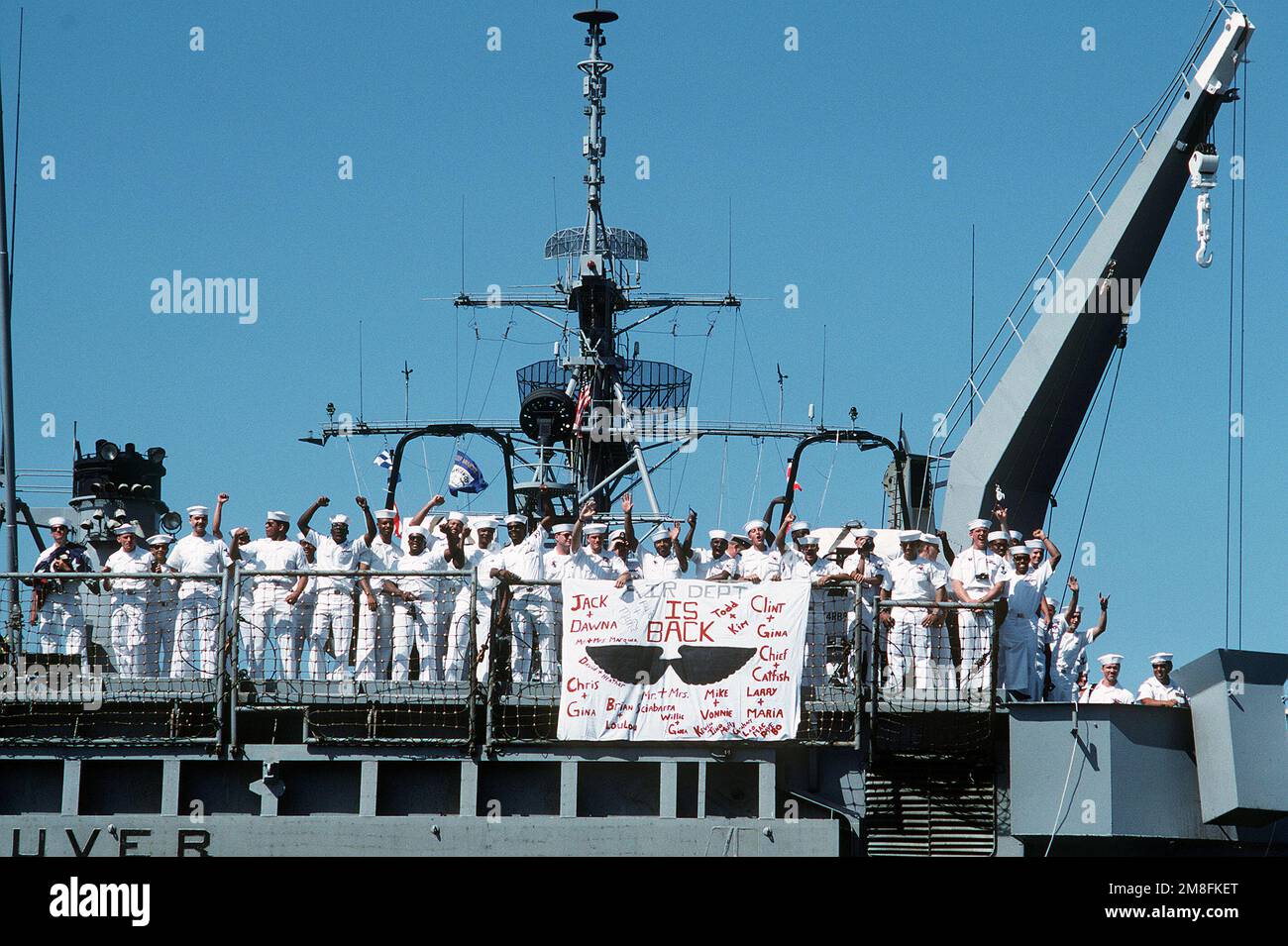 Sailors standing near the stern of the amphibious transport dock USS ...