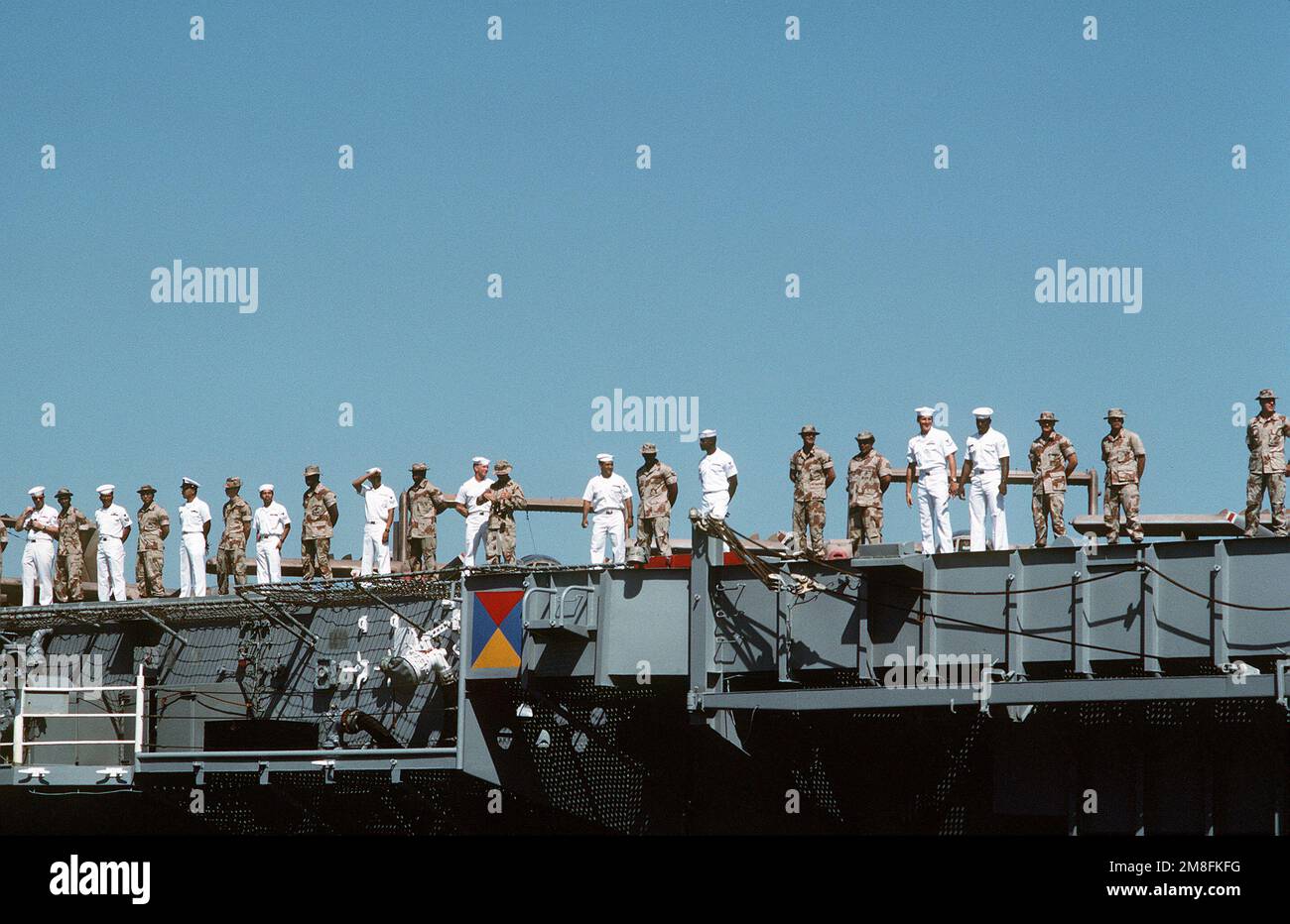 Sailors and Marines man the rails near the stern of the amphibious ...