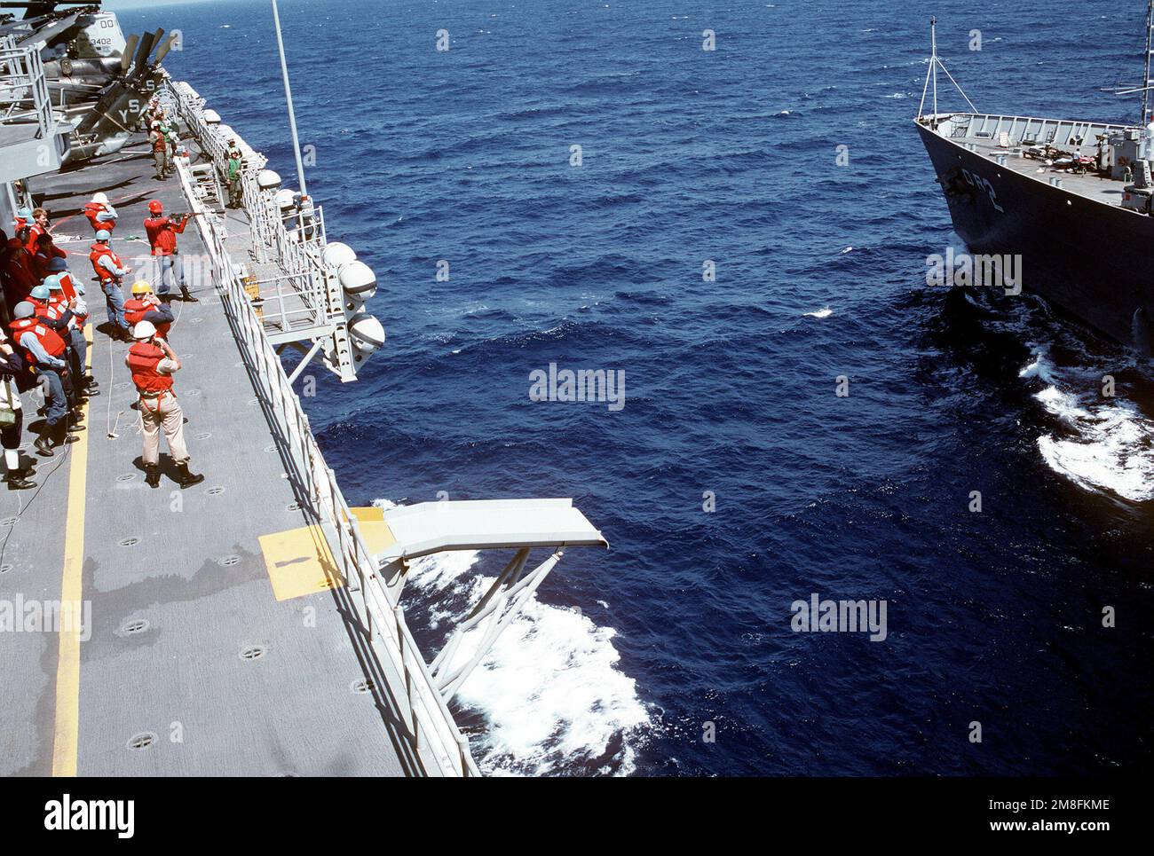 A crewman aboard the amphibious assault ship USS WASP (LHD-1), left ...