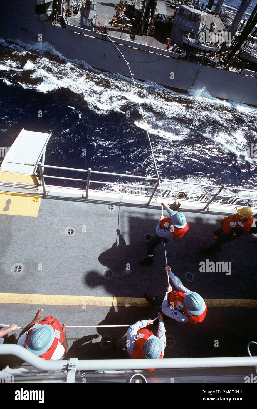 Sailors aboard the amphibious assault ship USS WASP (LHD-1) hang onto ...
