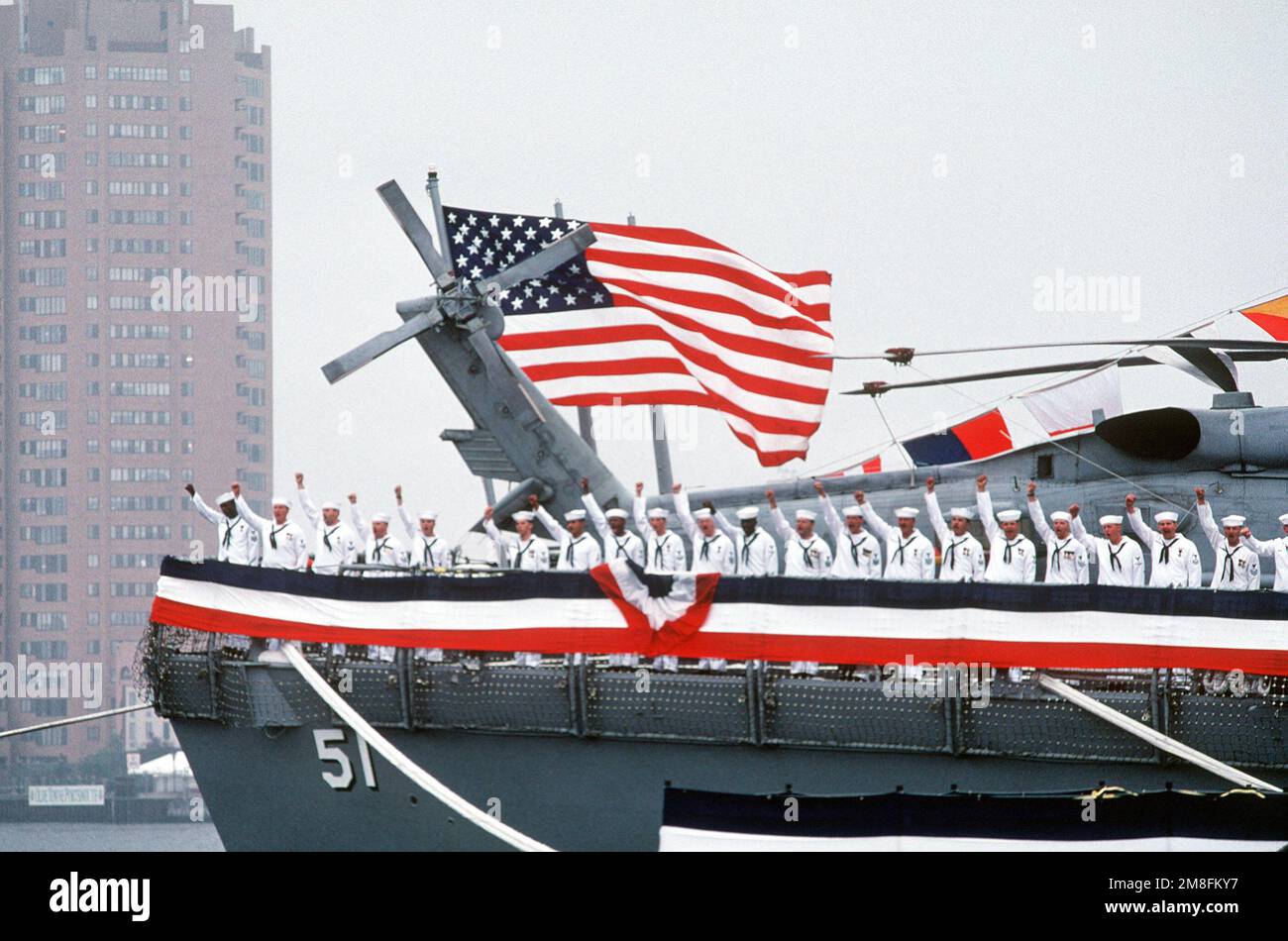 Crewmen man the rails of the guided missile destroyer USS ARLEIGH BURKE ...