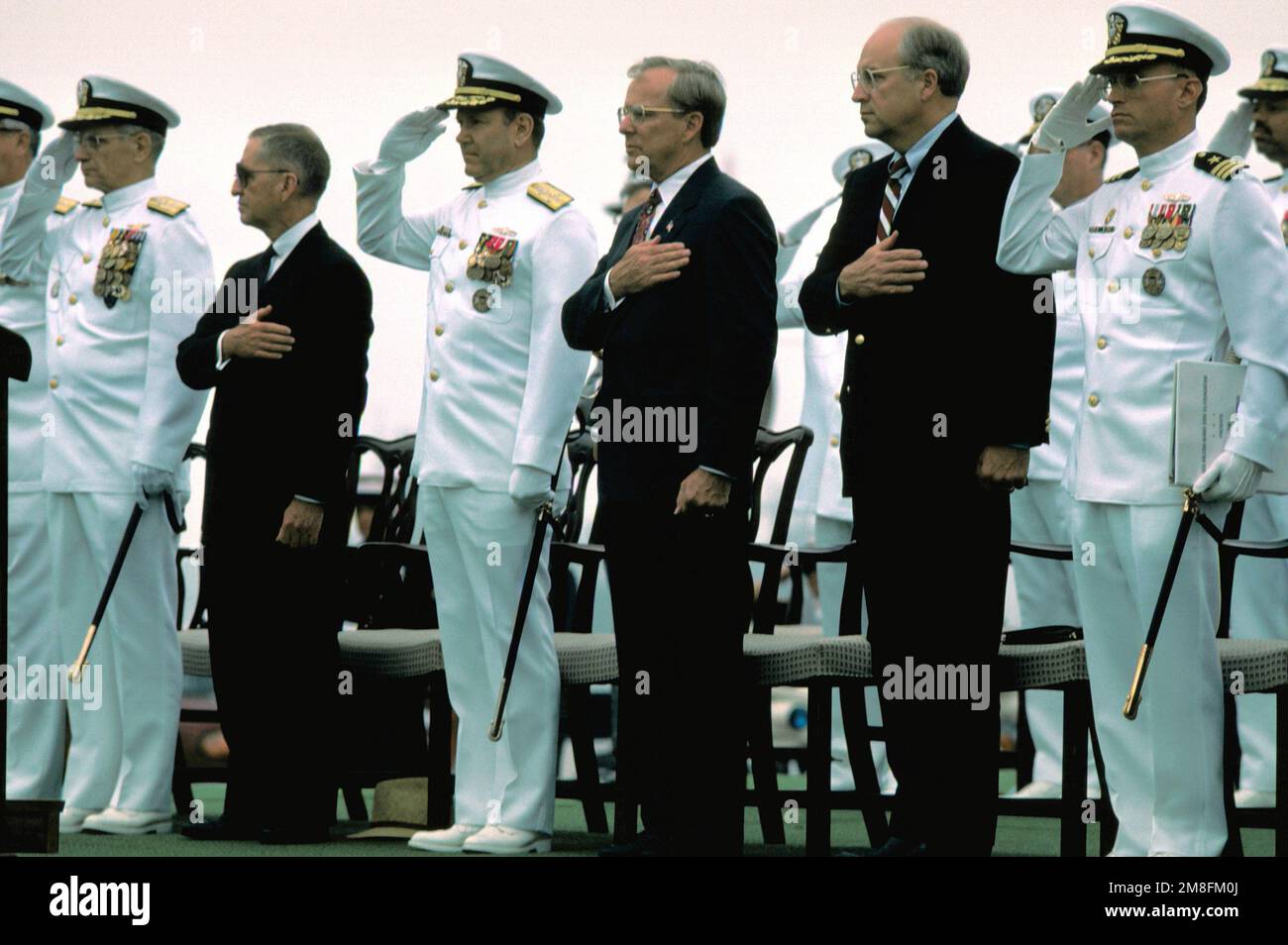 Officers and distinguished guests honor the flag during the ...