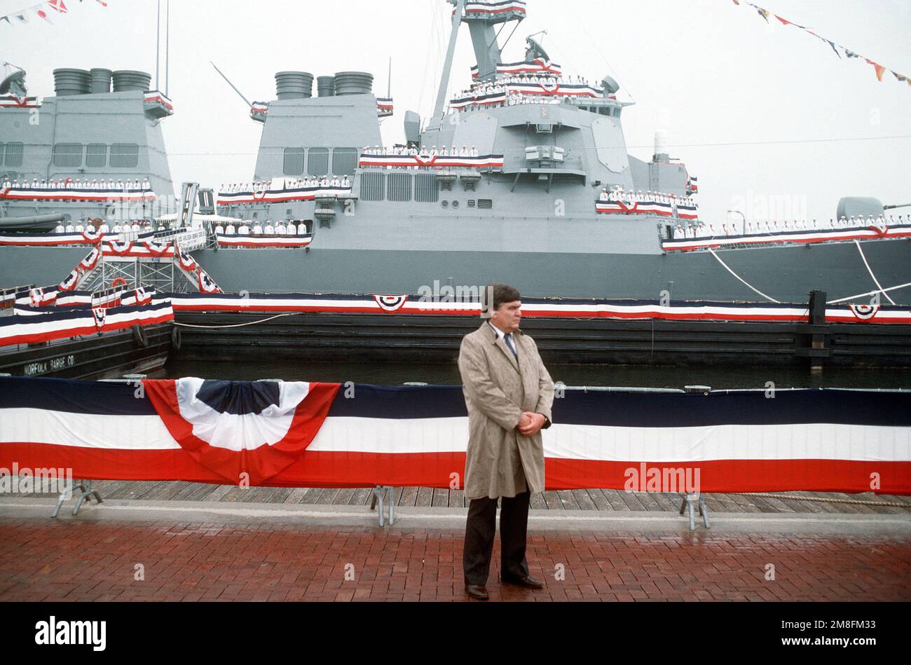 A security agent stands on the dock in front of the guided missile ...