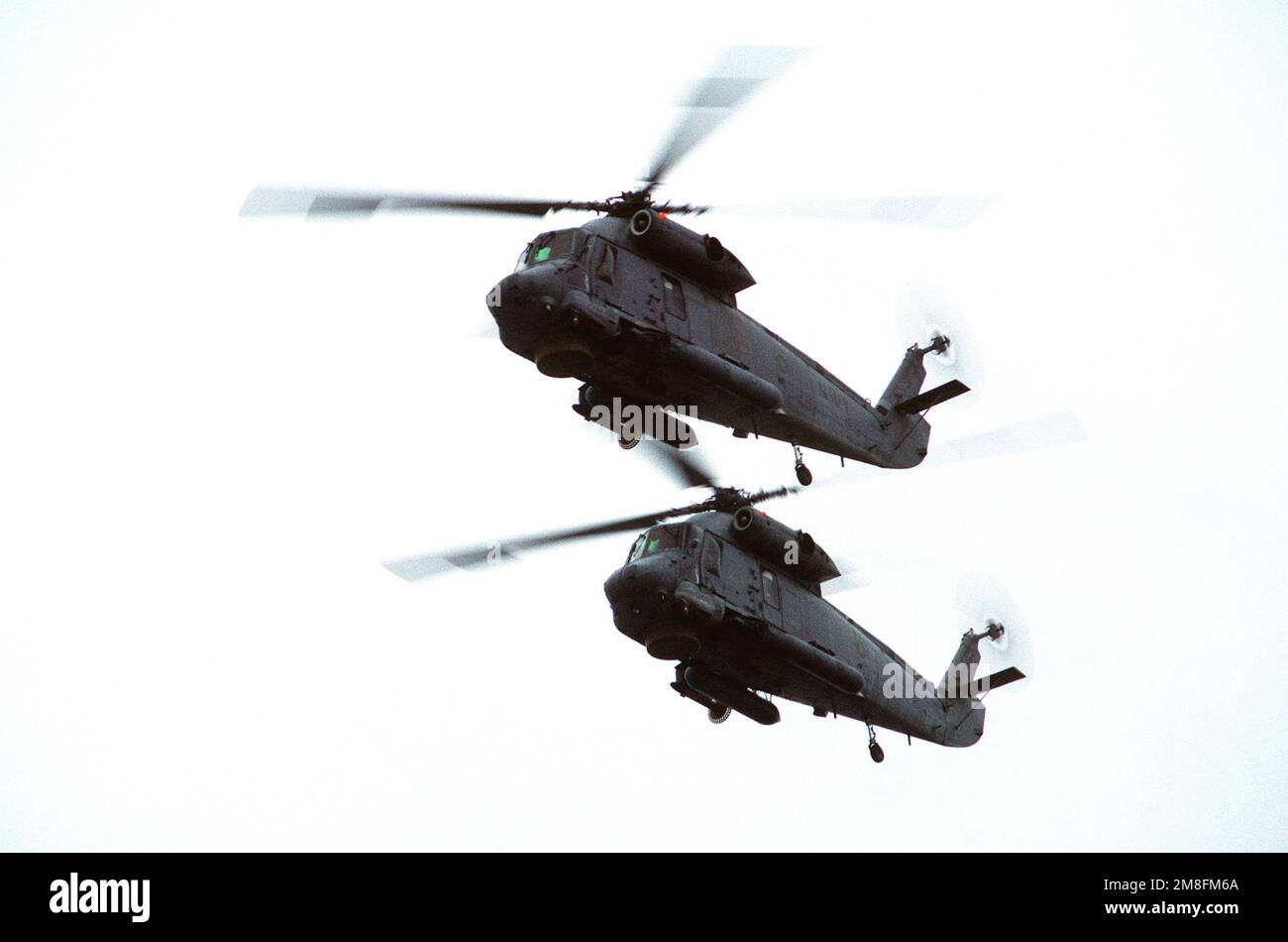 Two SH-2F Seasprite helicopters pass overhead during the commissioning ...