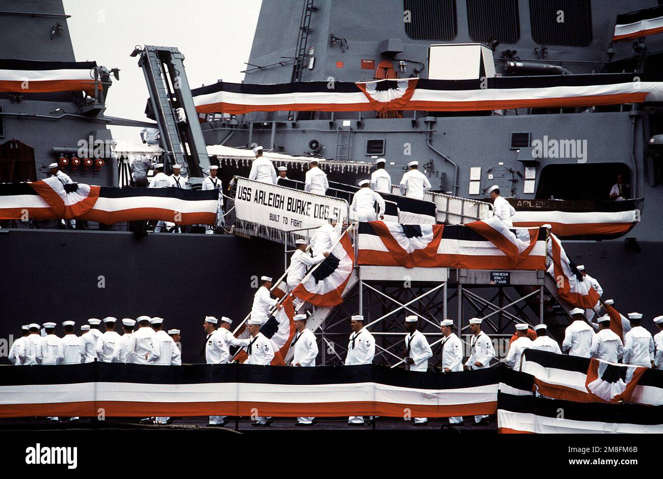 Crew members run aboard the guided missile destroyer USS ARLEIGH BURKE ...