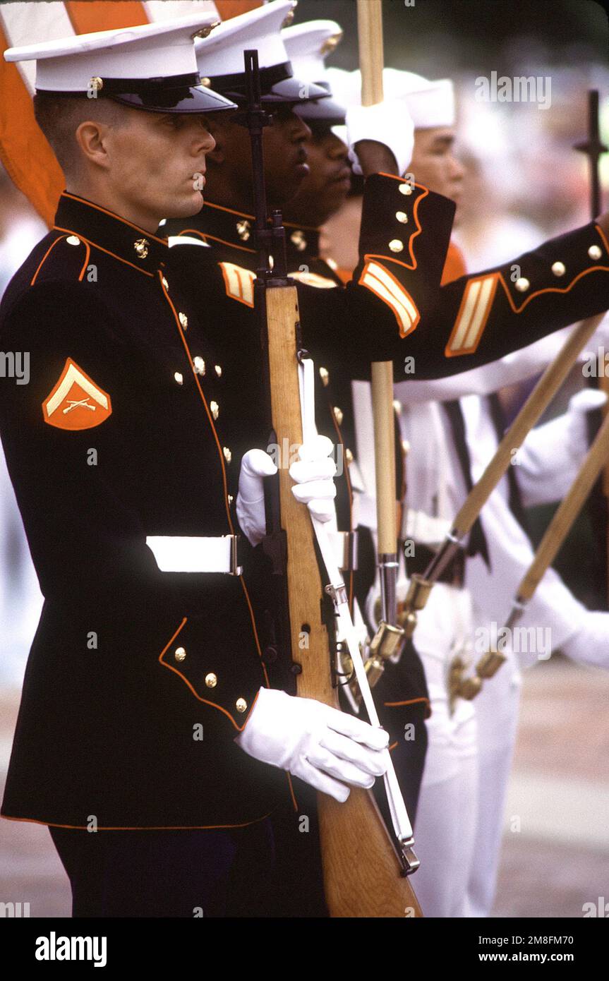 Members of a joint Navy-Marine Corps color guard present the colors ...