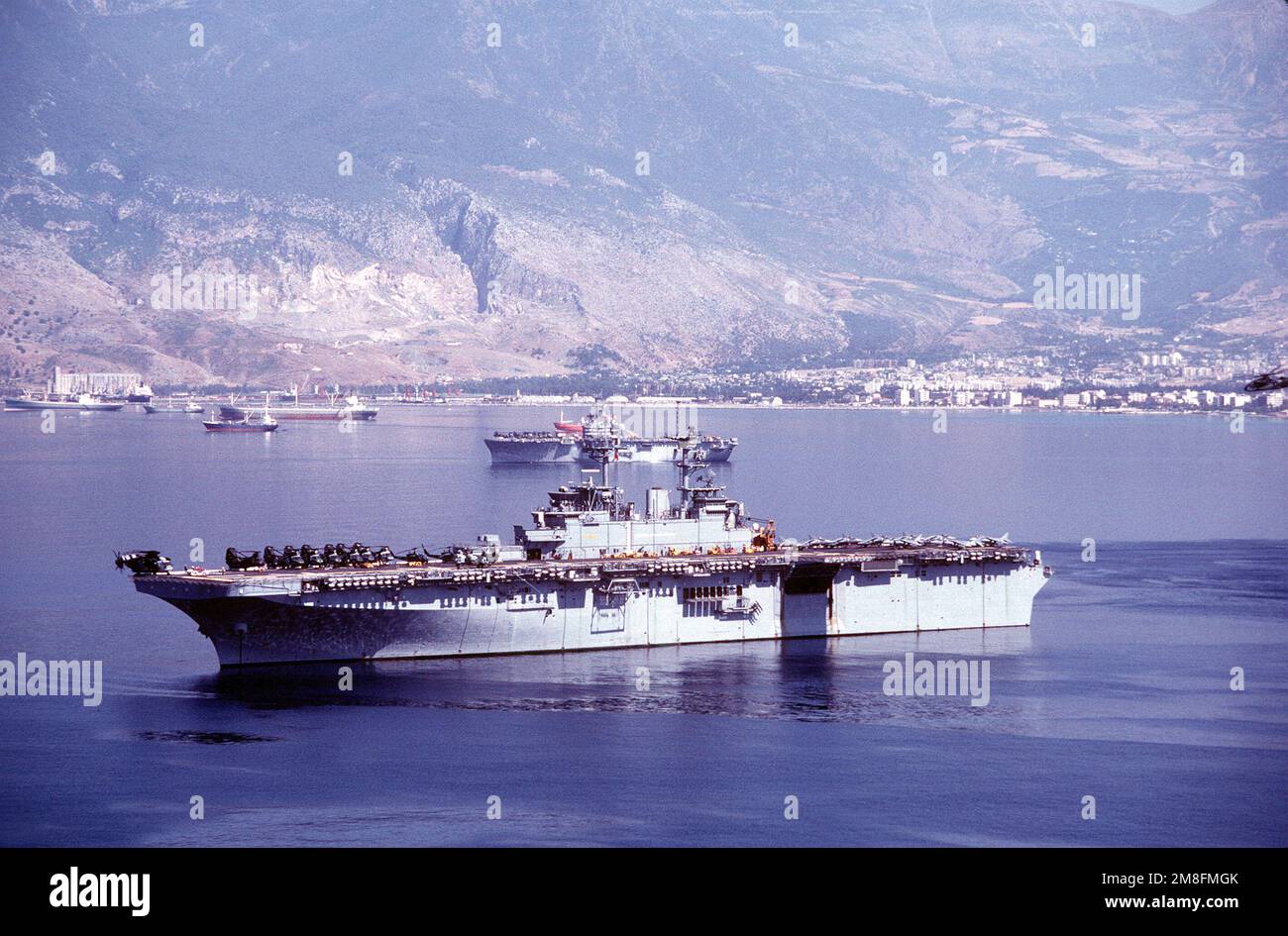 The amphibious assault ship USS WASP (LHD 1), foreground, lies at ...
