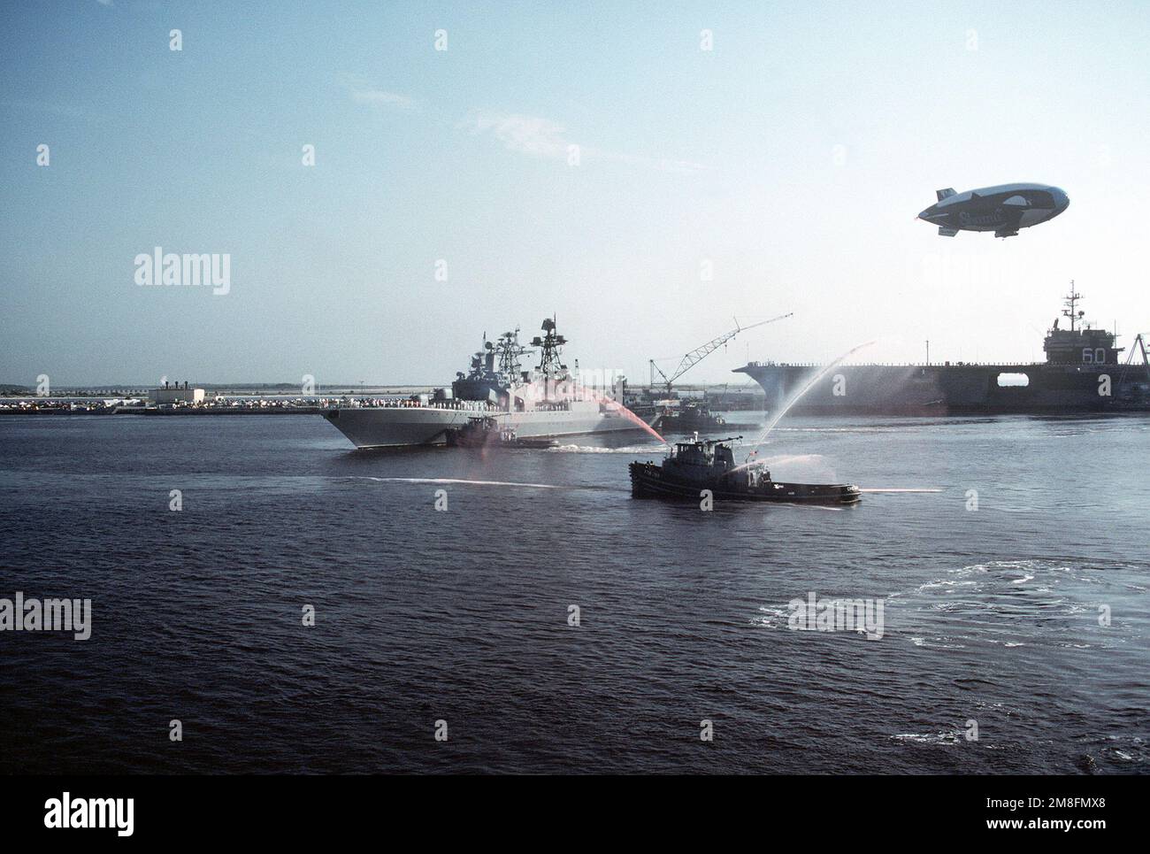 Harbor tugs maneuver the Soviet Udaloy class destroyer SIMFEROPOL as ...