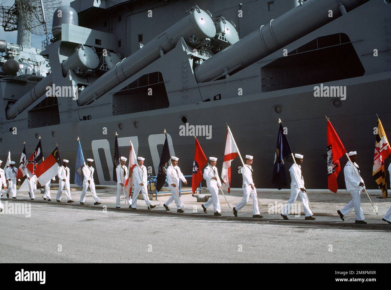 U.S. sailors carrying state flags parade past the Soviet Slava class ...