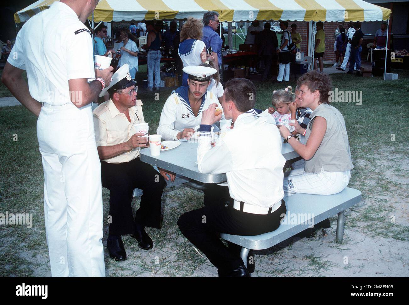Soviet sailors share a table with an American family during a picnic at ...
