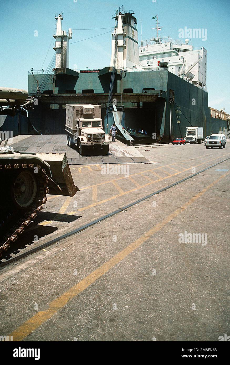 An M-35 2.5-ton cargo truck carrying a shelter is driven down the stern ...