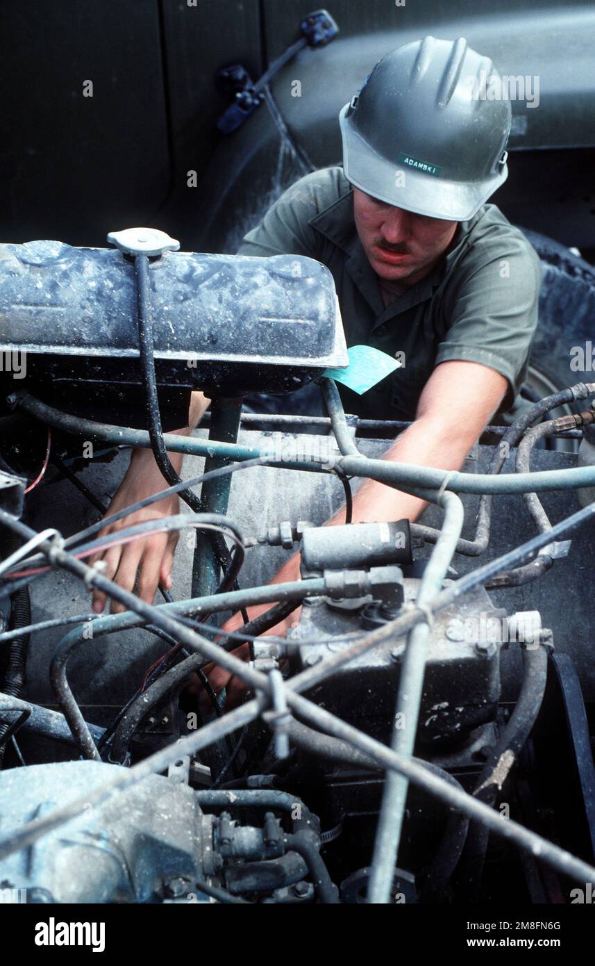 A member of a construction battalion (SEABEE) works on an ash-covered ...