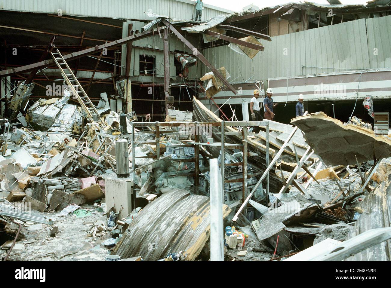 Filipino workers survey the destroyed electronics department of the ...
