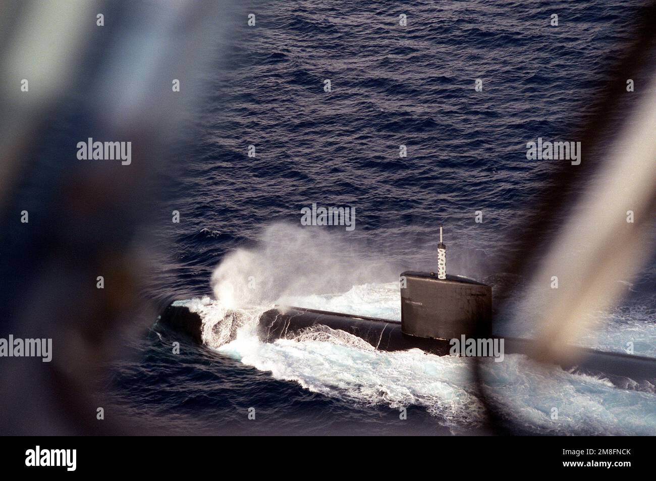 Spray blows back from the bow of the nuclear-powered attack submarine ...