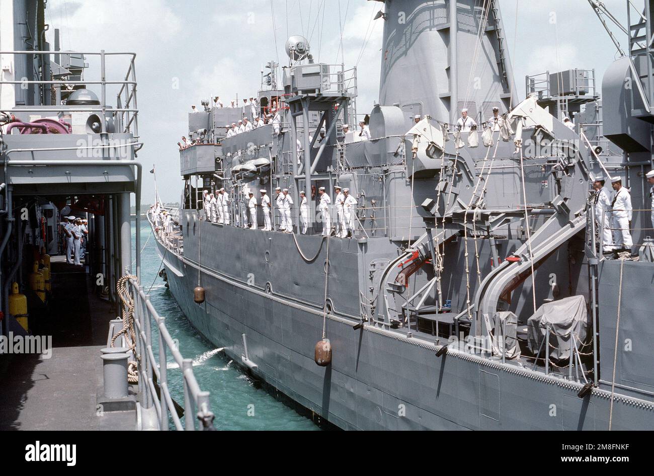 Crew members aboard a Knox class frigate, right, man the rail as the ...