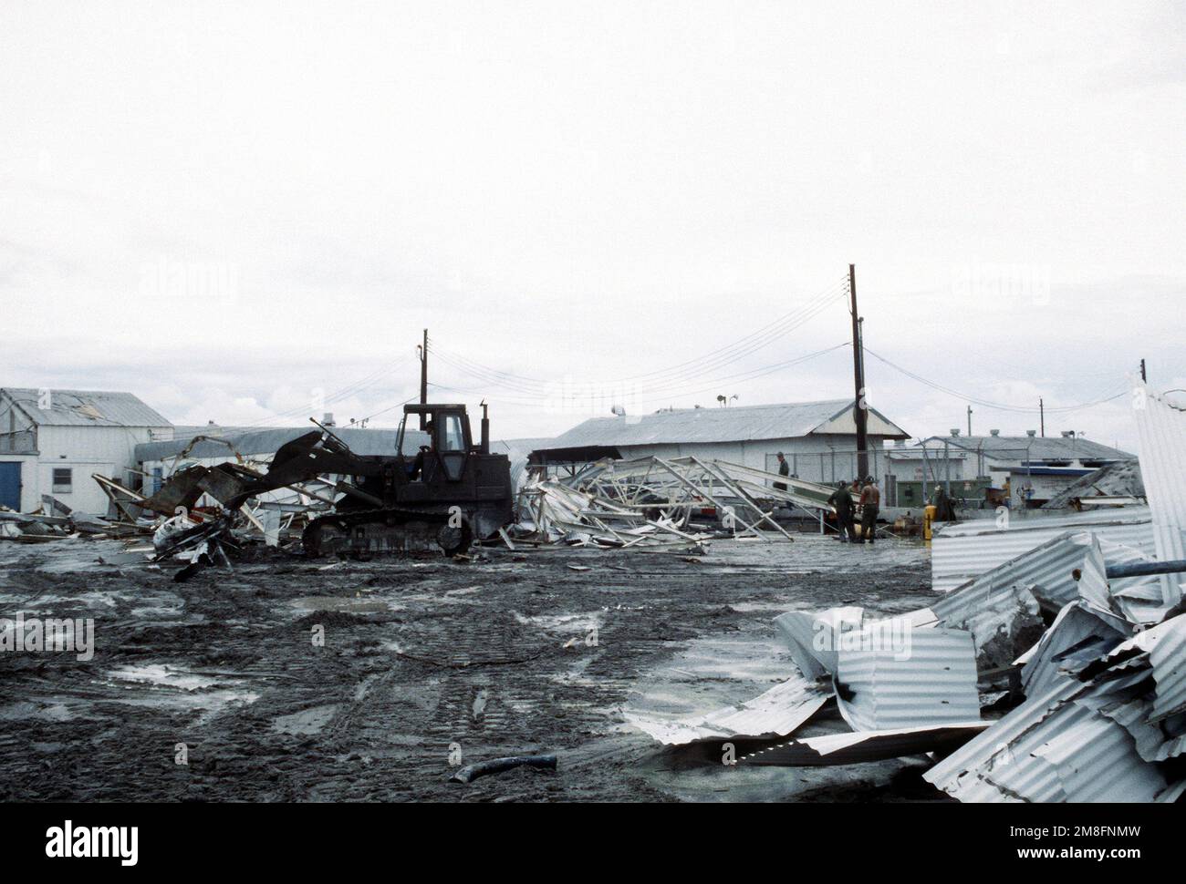 A Seabee uses a bulldozer to clear away the remains of the Fleet ...