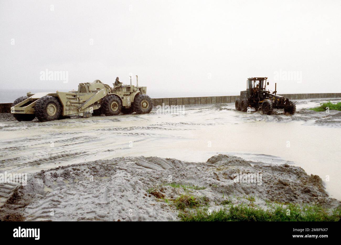 Seabees use a motorized earthmoving scraper, left, and a John Deere ...
