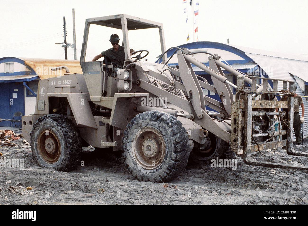 A Seabee uses an M6K rough terrain forklift to remove debris from the ...