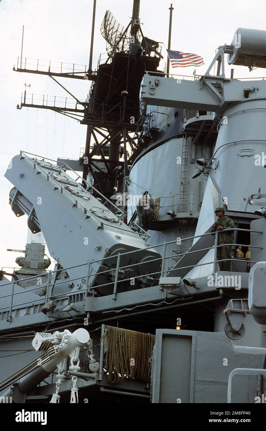 A lookout stands watch near a raised Tomahawk missile armored box ...