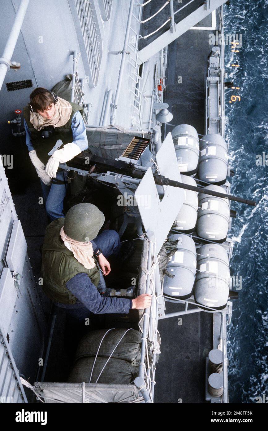 Two sailors man an M-2 .50-caliber machine gun while on watch aboard ...