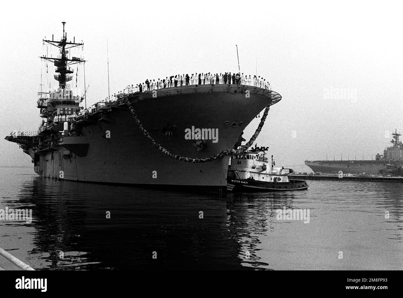 The amphibious assault ship USS TRIPOLI (LPH-10), a garland hung around ...