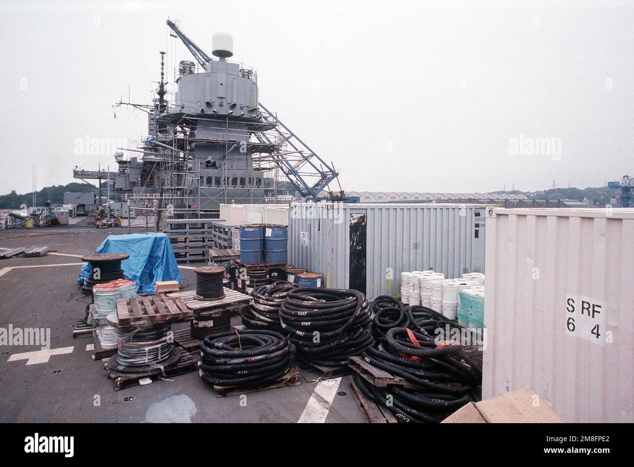 Shelters cables and other equipment sit on the deck of the amphibious ...