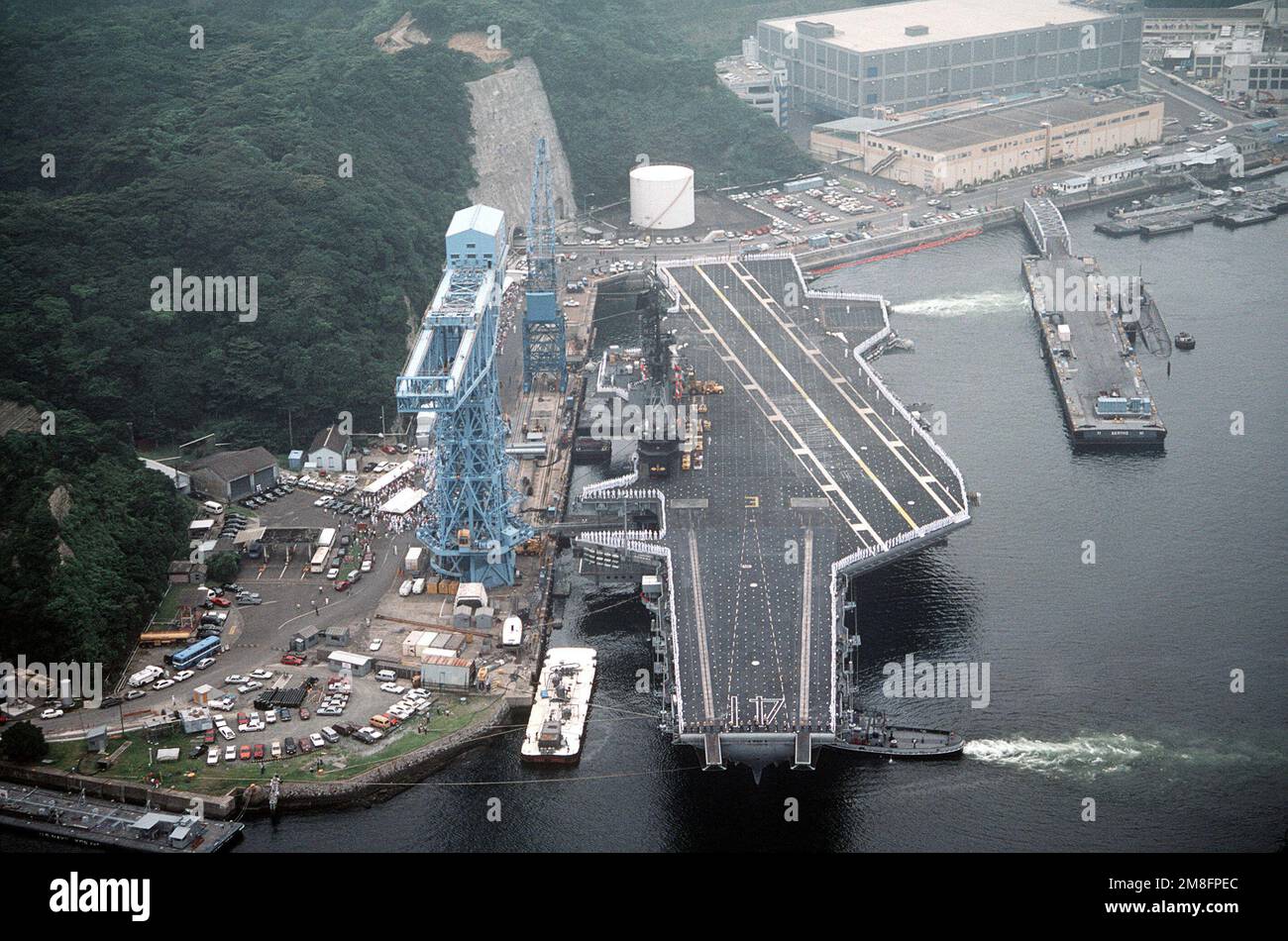 The crew of the aircraft carrier USS MIDWAY (CV-41) mans the rails as ...