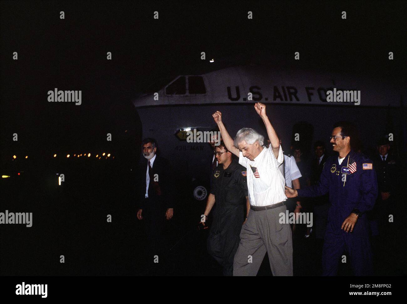 American hostage Edward Austin Tracy raises his arms to a crowd of well ...