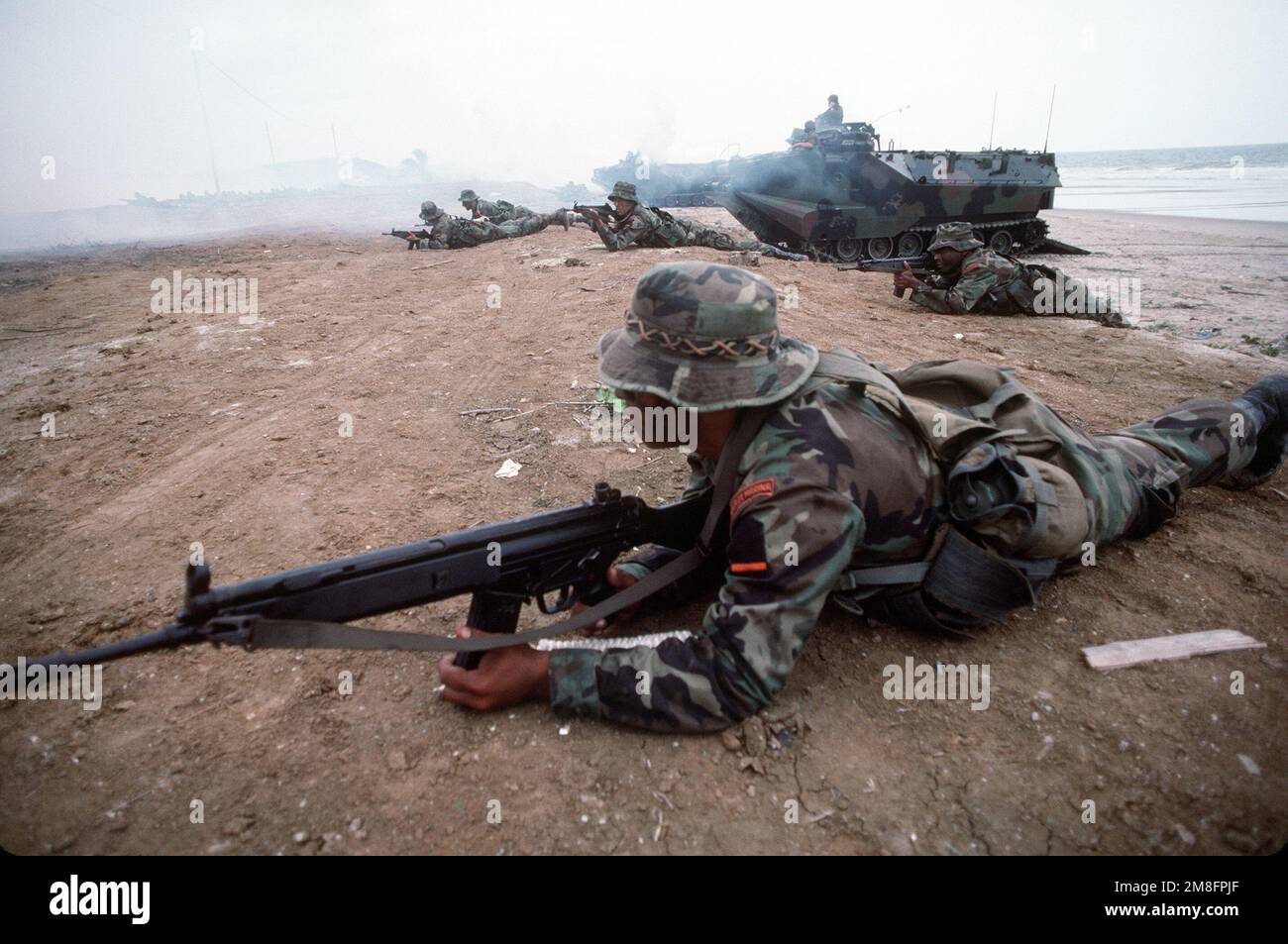 An Ecuadoran marine armed with an HK-33E rifle lies prone at the top of ...