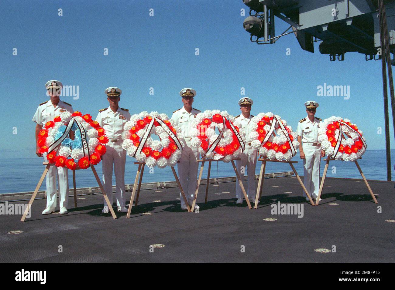 U.S. Navy officers stand beside wreaths representing the four Japanese ...