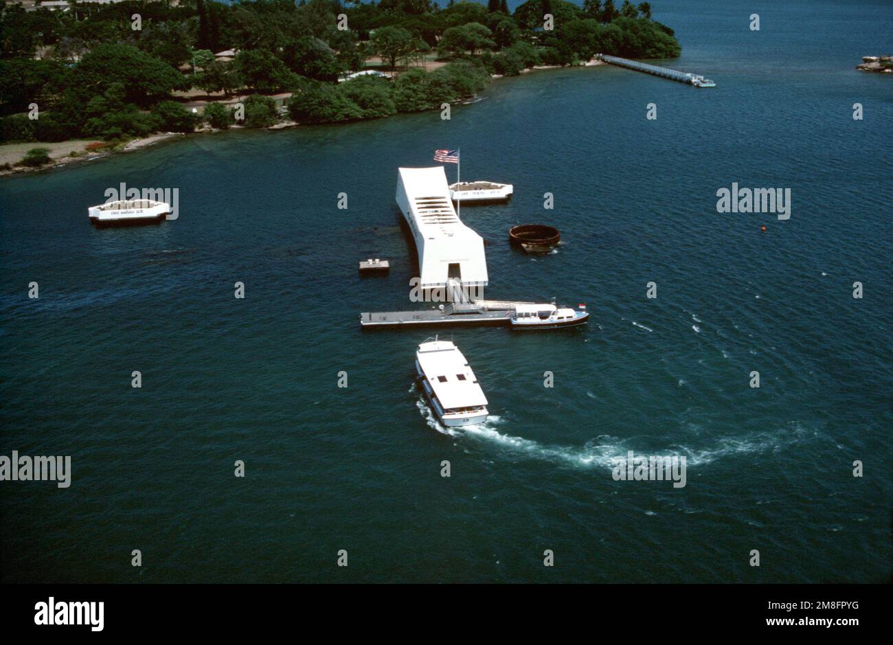 A passenger ferry approaches the USS ARIZONA Memorial. Ford Island is ...