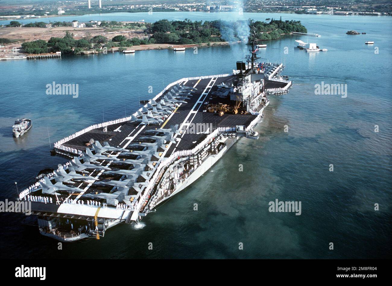 The crew of the aircraft carrier USS MIDWAY (CV-41) mans the rails as ...