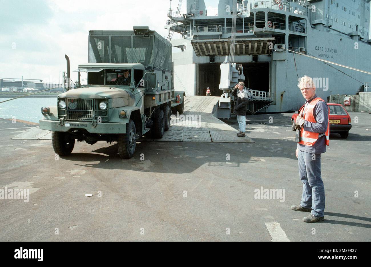 Dutch dock workers watch as an M-35 2.5-ton truck carrying a ...