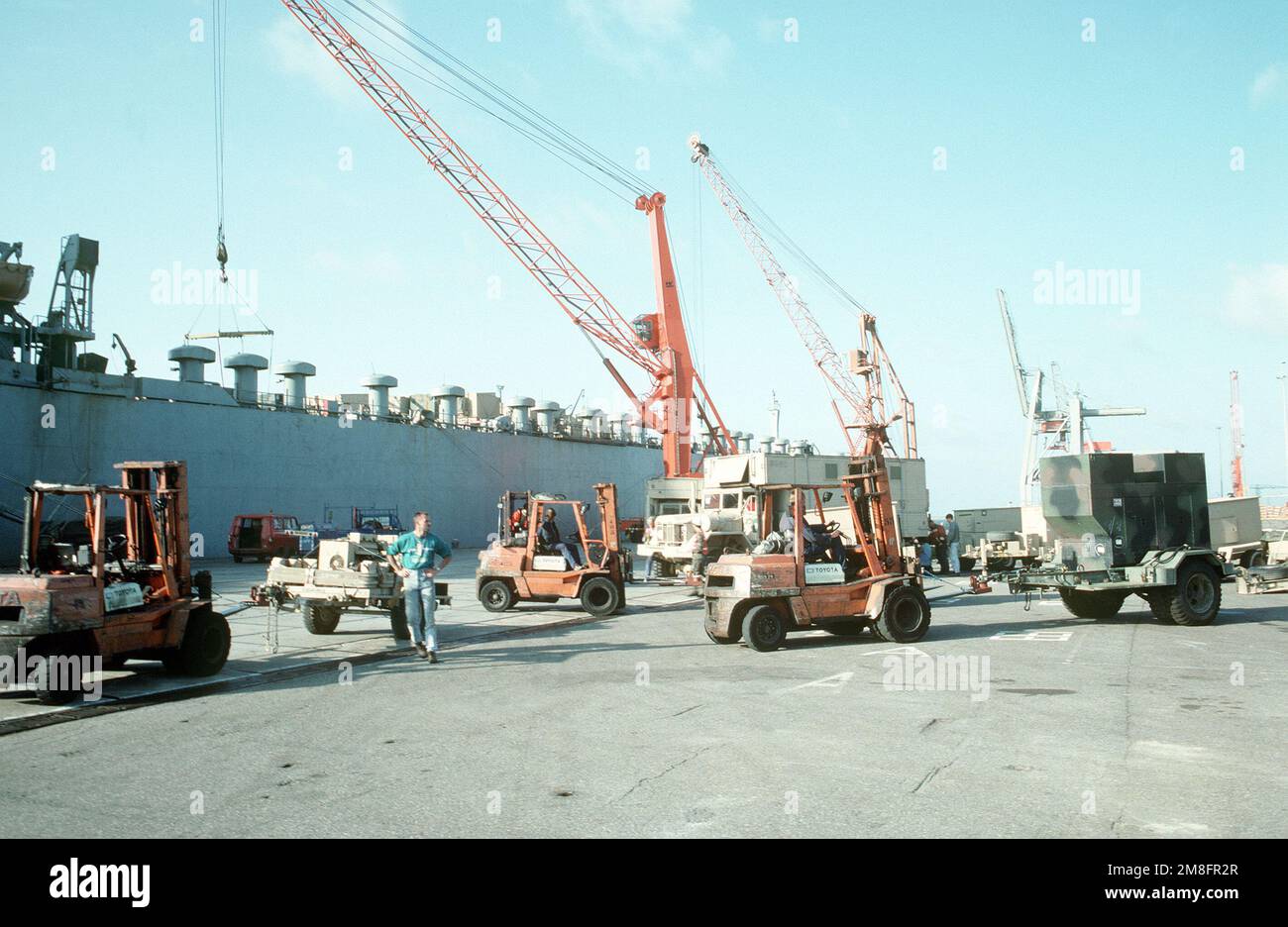 Duth dock workers use forklift to push trailers over to a staging area ...