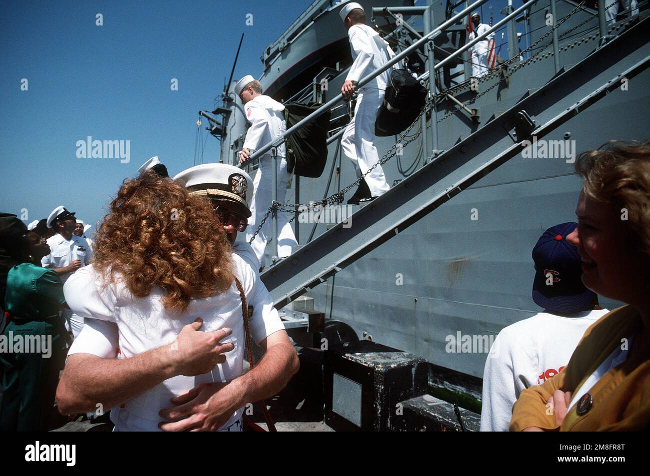 An officer is reunited with his wife as other crew members disembark ...