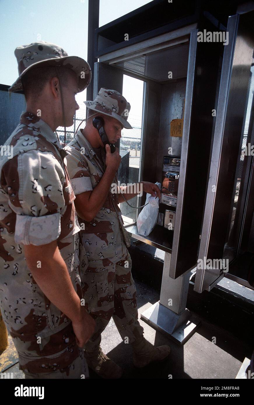Lance CPL. Daniel Wirth makes a phone call as Lance CPL. John Winters ...
