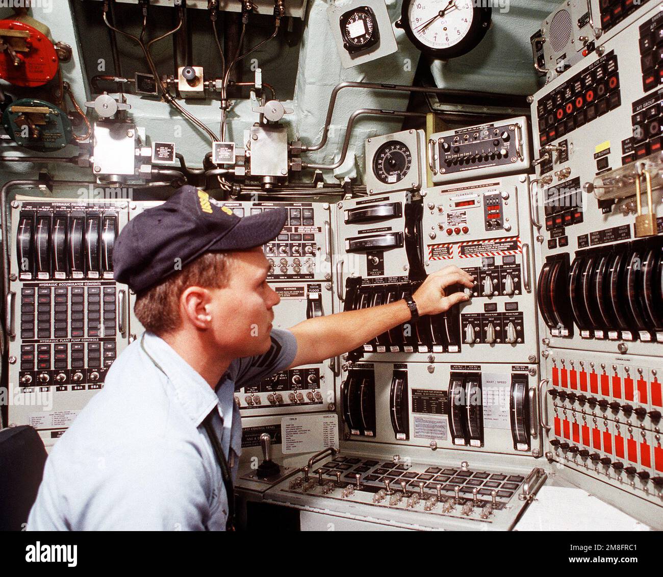 The chief of the watch adjusts equipment at the ballast control panel ...