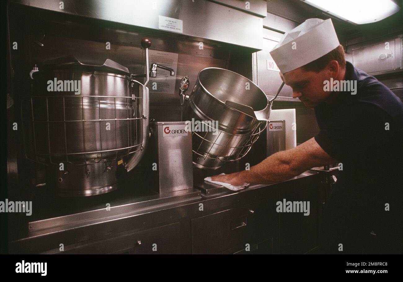 A mess management specialist cleans the galley aboard the nuclear ...