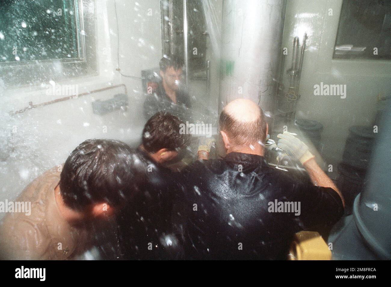 Crew members attach a temporary patch to a leaking pipe in a submarine ...