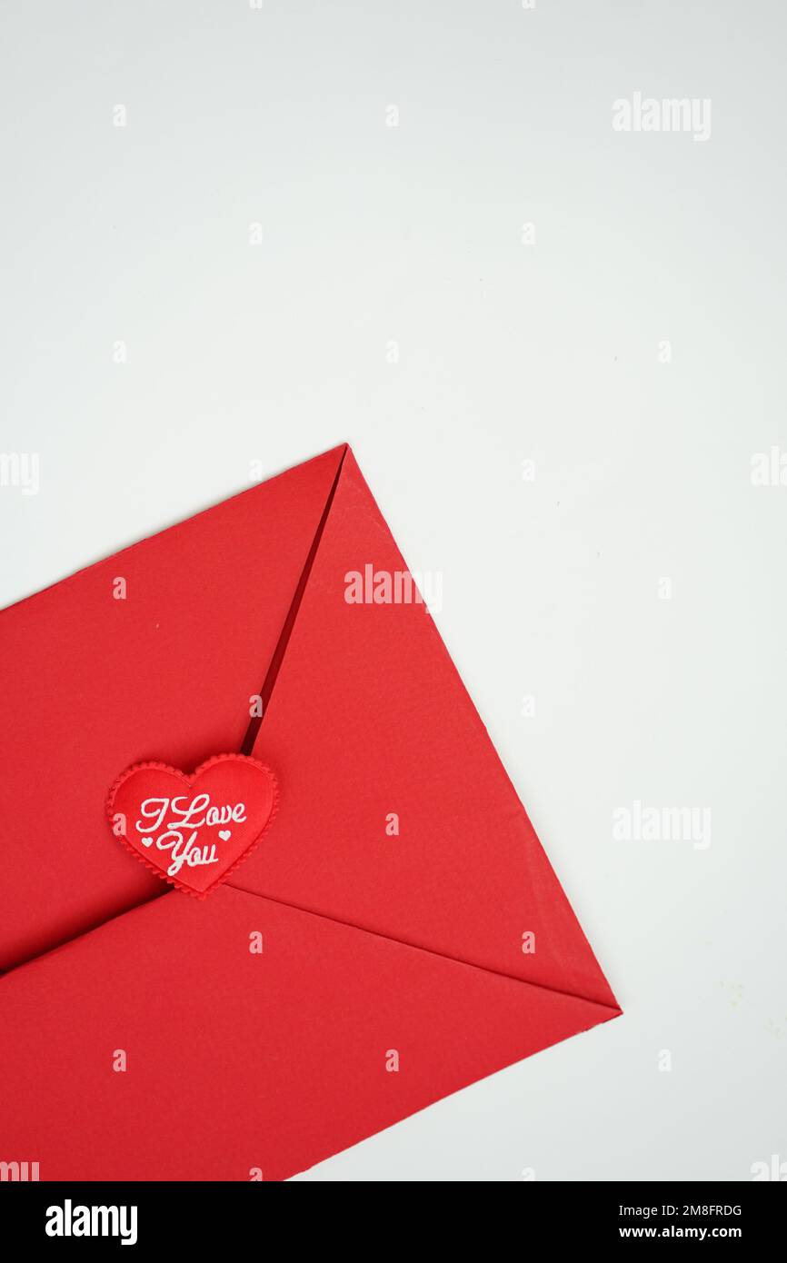 On a white vertical background, a red envelope with a red heart on ...