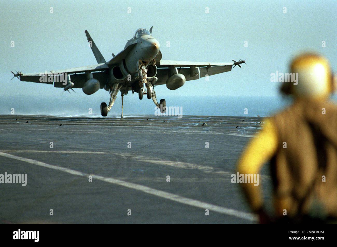 An F/A -18C Hornet aircraft catches the arresting cable as it lands on ...