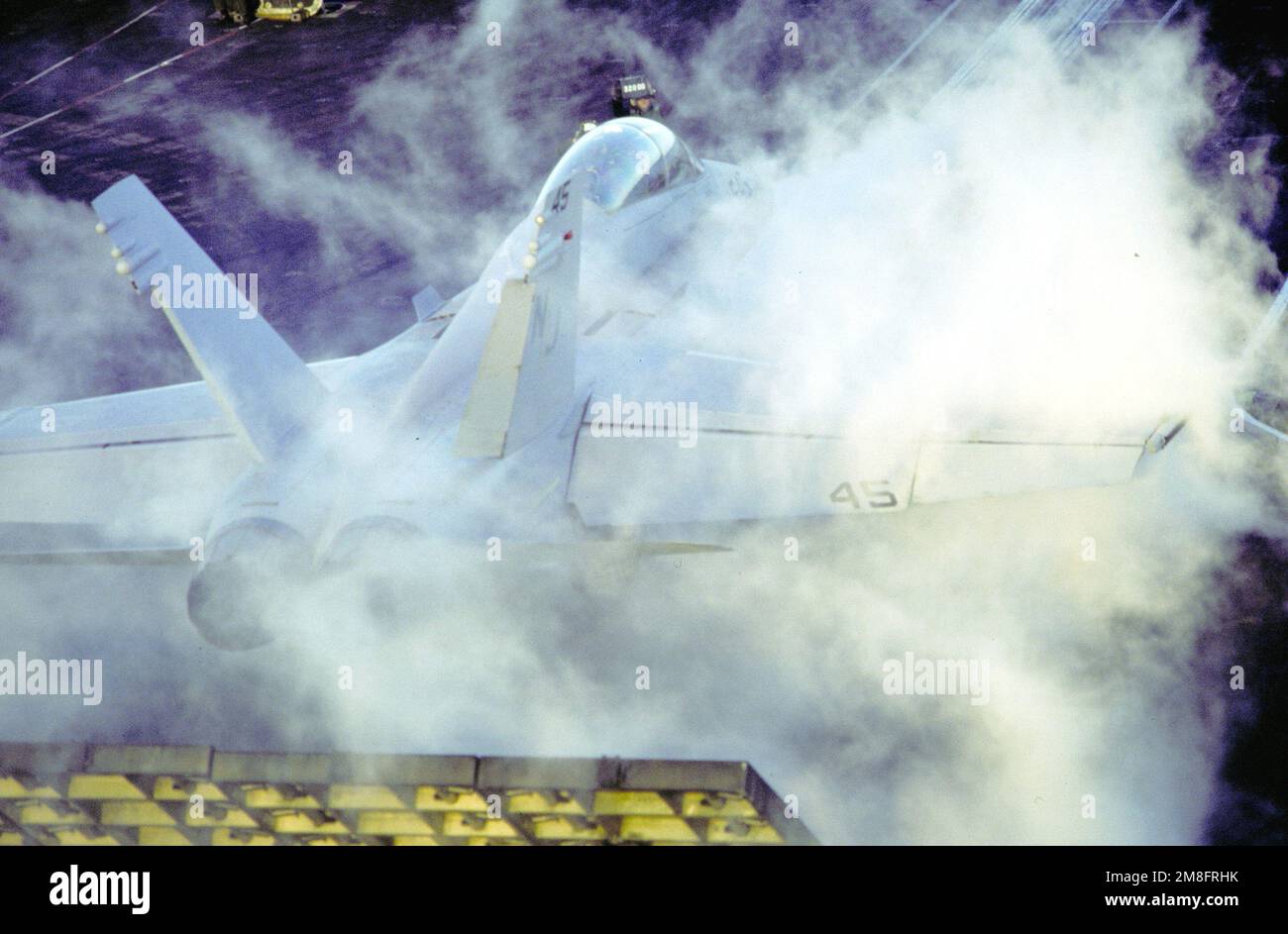 Steam from the catapult tracks surrounds a Strike Fighter Squadron 125 ...