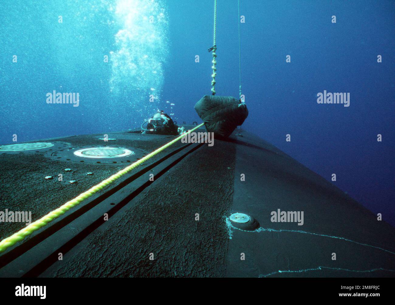 A member of a Navy sea-air-land (SEAL) team emerges from the hull of a ...