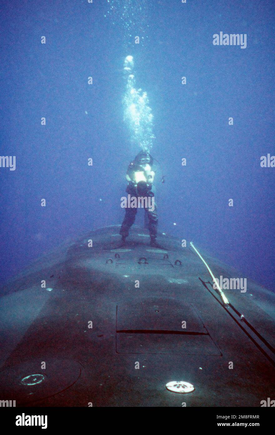 Photographer's Mate (Diver) 2nd Class David Tilton, holds his position ...