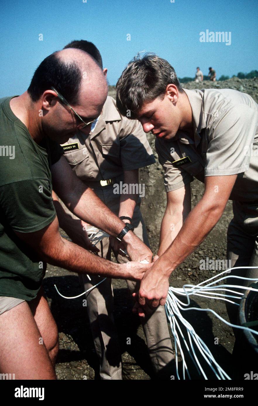 Two midshipmen visiting from the U.S. Naval Academy assist an explosive ...
