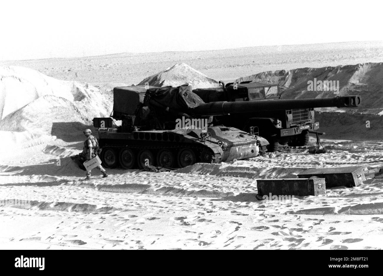 A Marine from Btry. R, 5th Bn., 11th Marines, walks past one of his unit's M-110A2 self ...