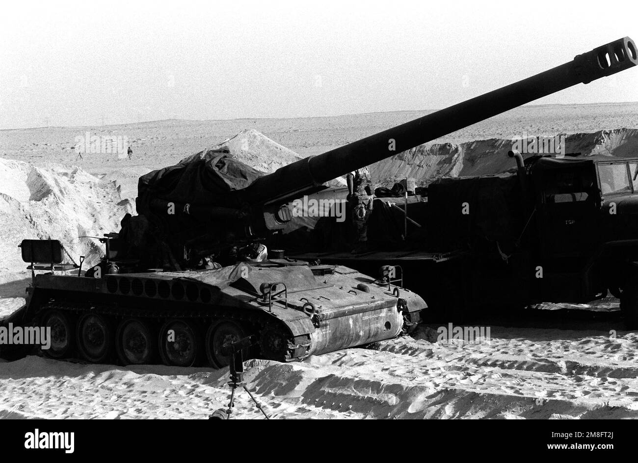 A Marine stands on the side of an M-923 5-ton cargo truck parked beside ...