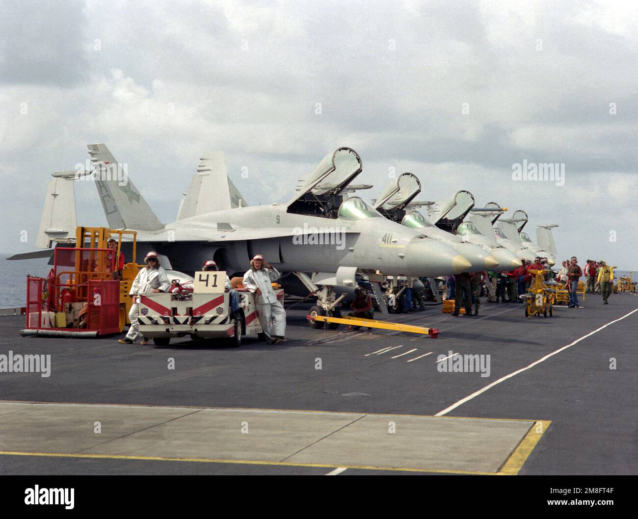 Members of the crash, rescue and salvage team stand by as flight deck ...